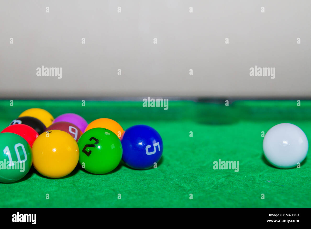 Children's pool table game with multicolored balls Stock Photo - Alamy