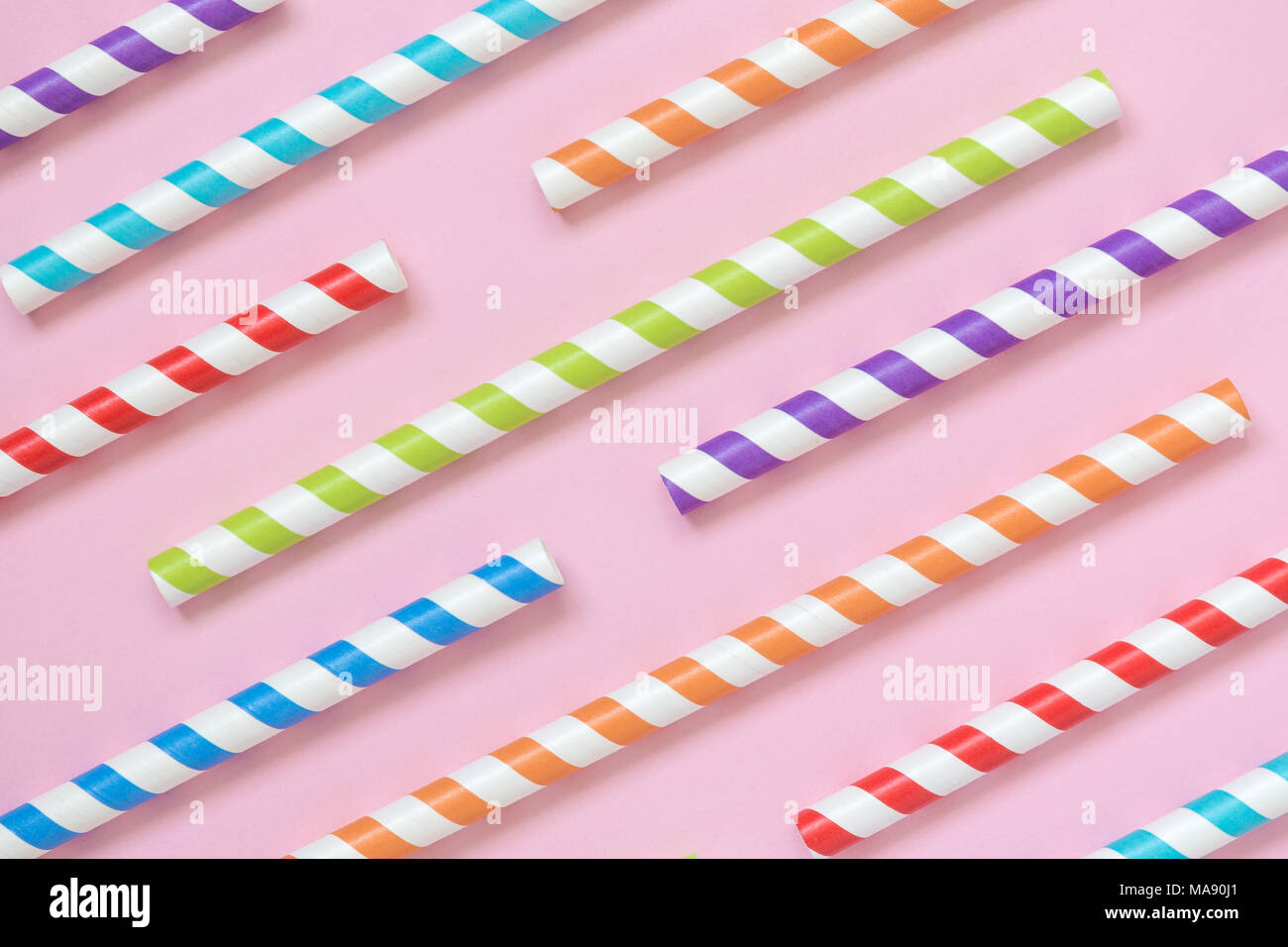 Colorful striped drinking straws pattern on pastel pink background ...