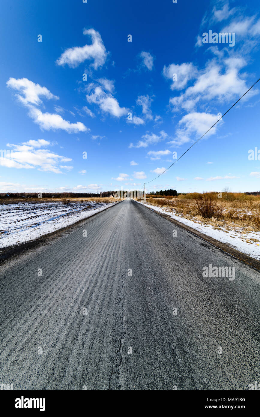 snowy winter road covered in deep snow with car tire tracks going in ...