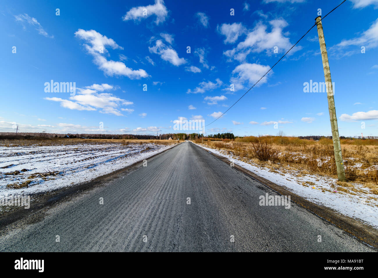 snowy winter road covered in deep snow with car tire tracks going in ...