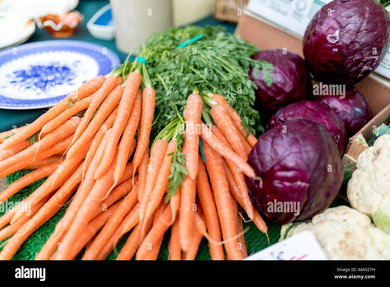 A bunch of fresh organic carrots on an English market stall in England ...