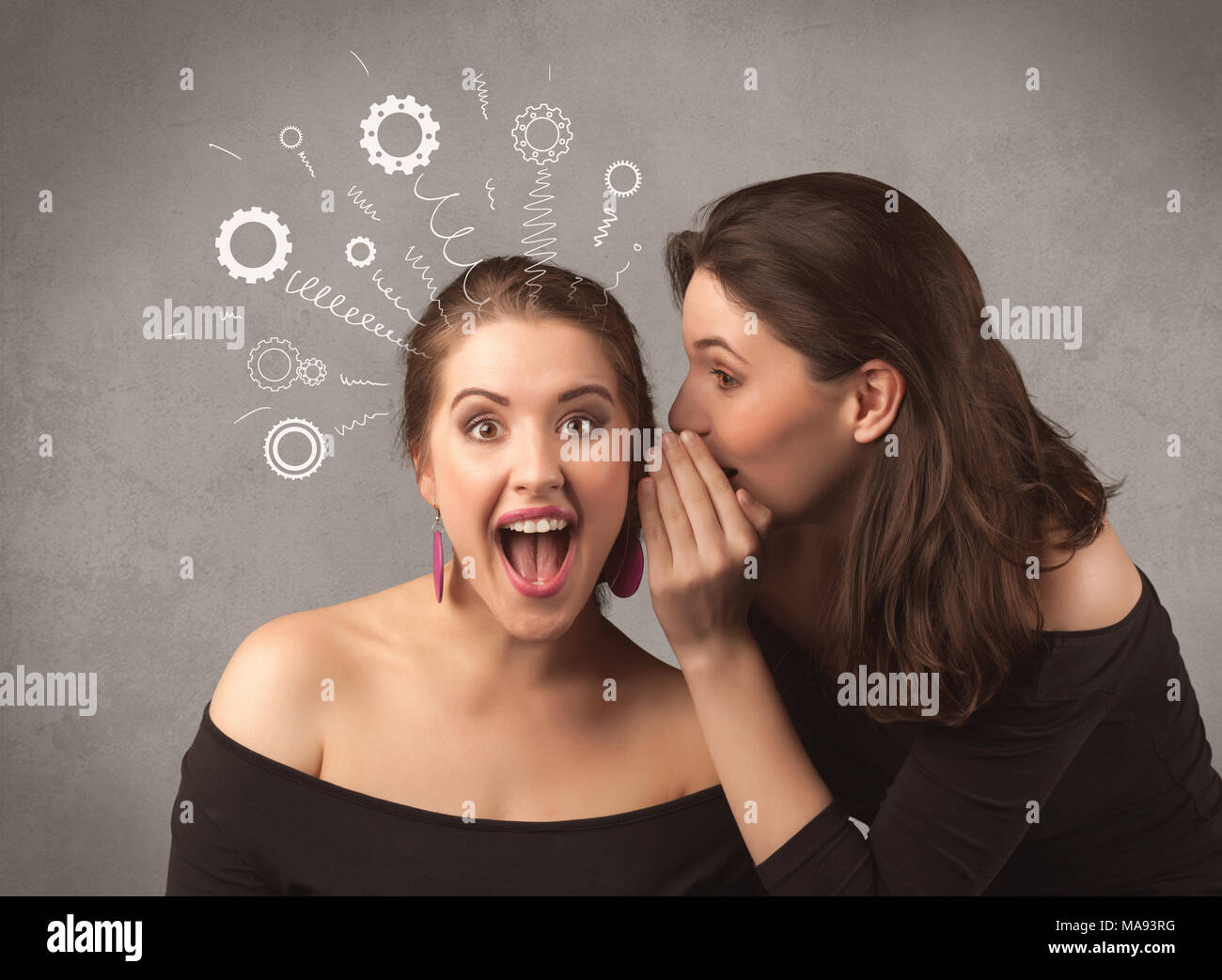 Two girlfriends in elegant black dress sharing secrets with each other ...