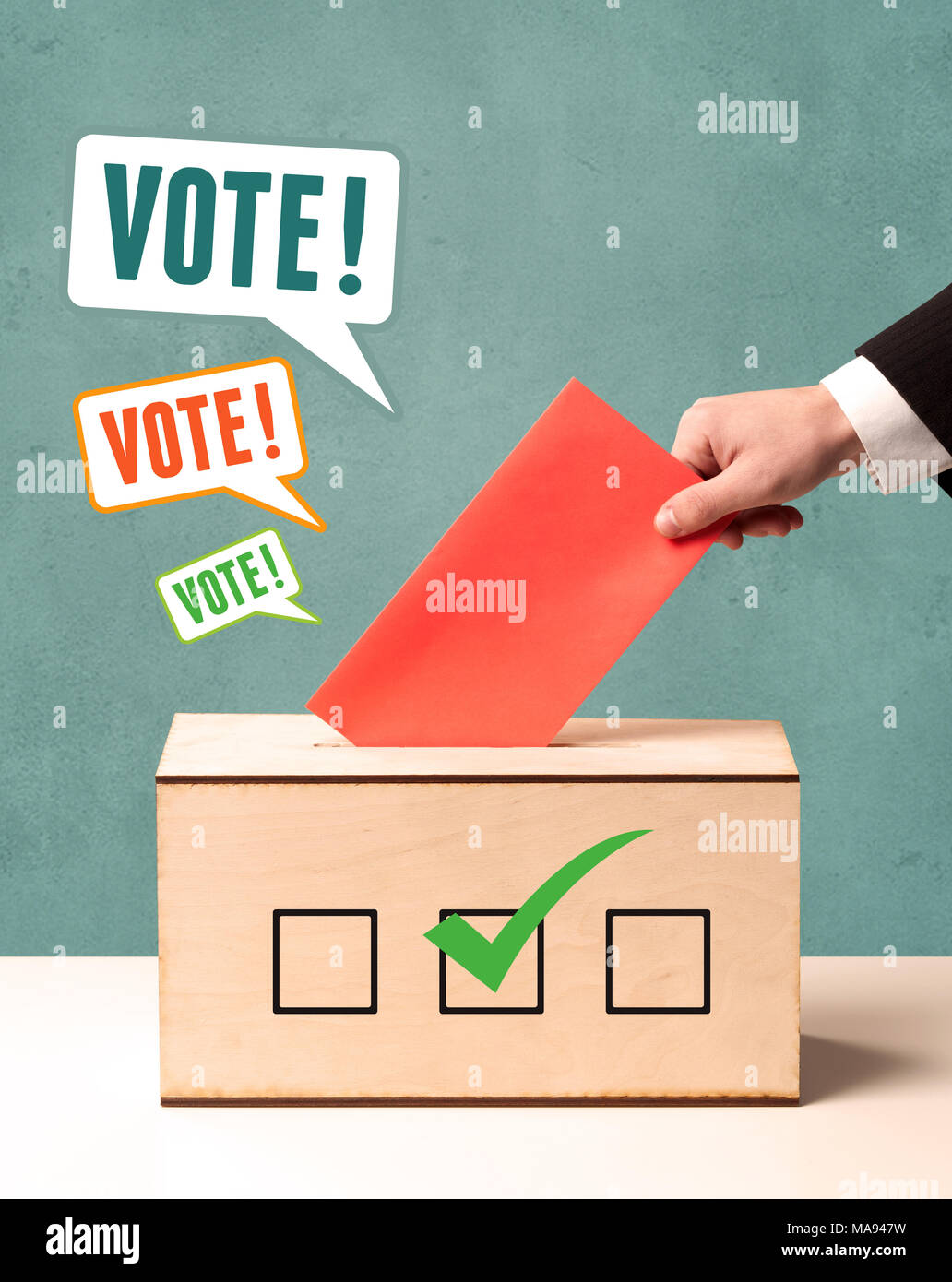 A hand placing a voting slip into a ballot box Stock Photo - Alamy