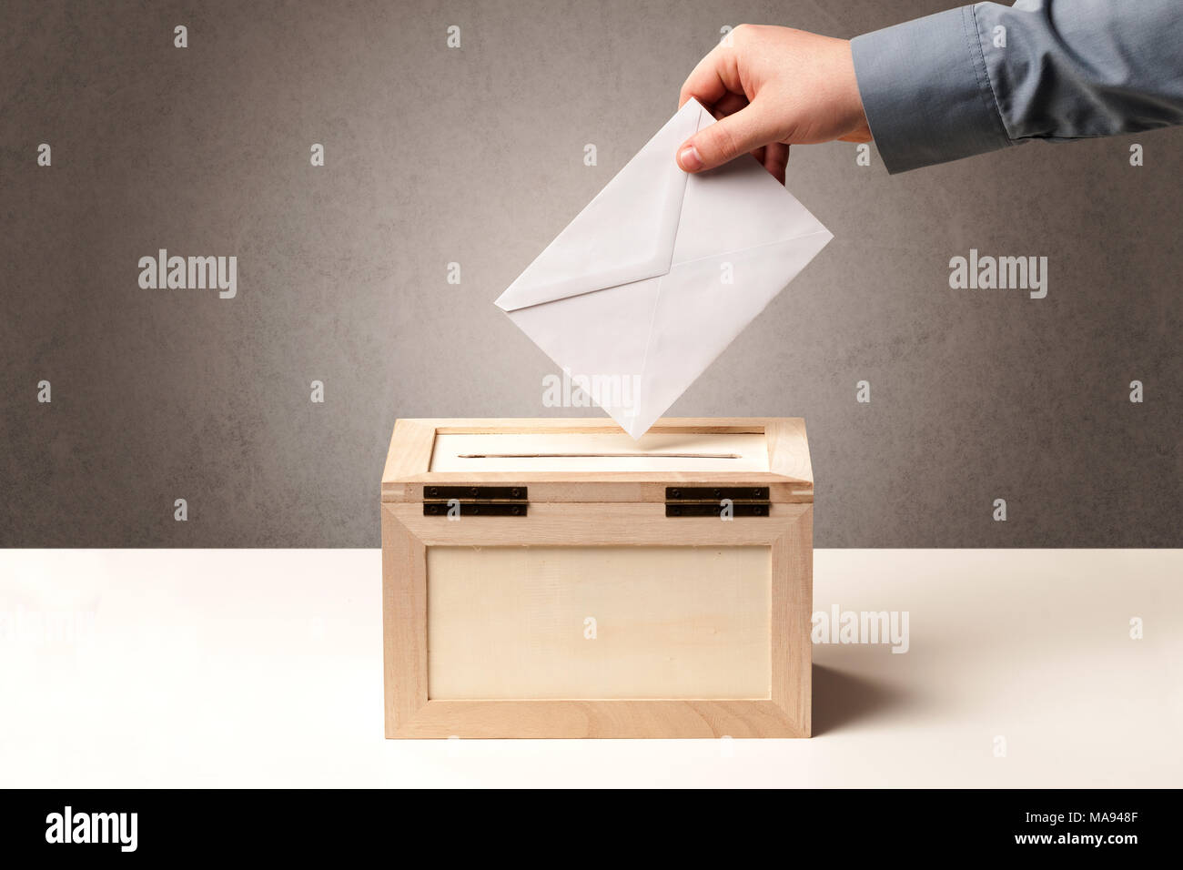 Ballot box with person casting vote on blank voting slip, grungy ...