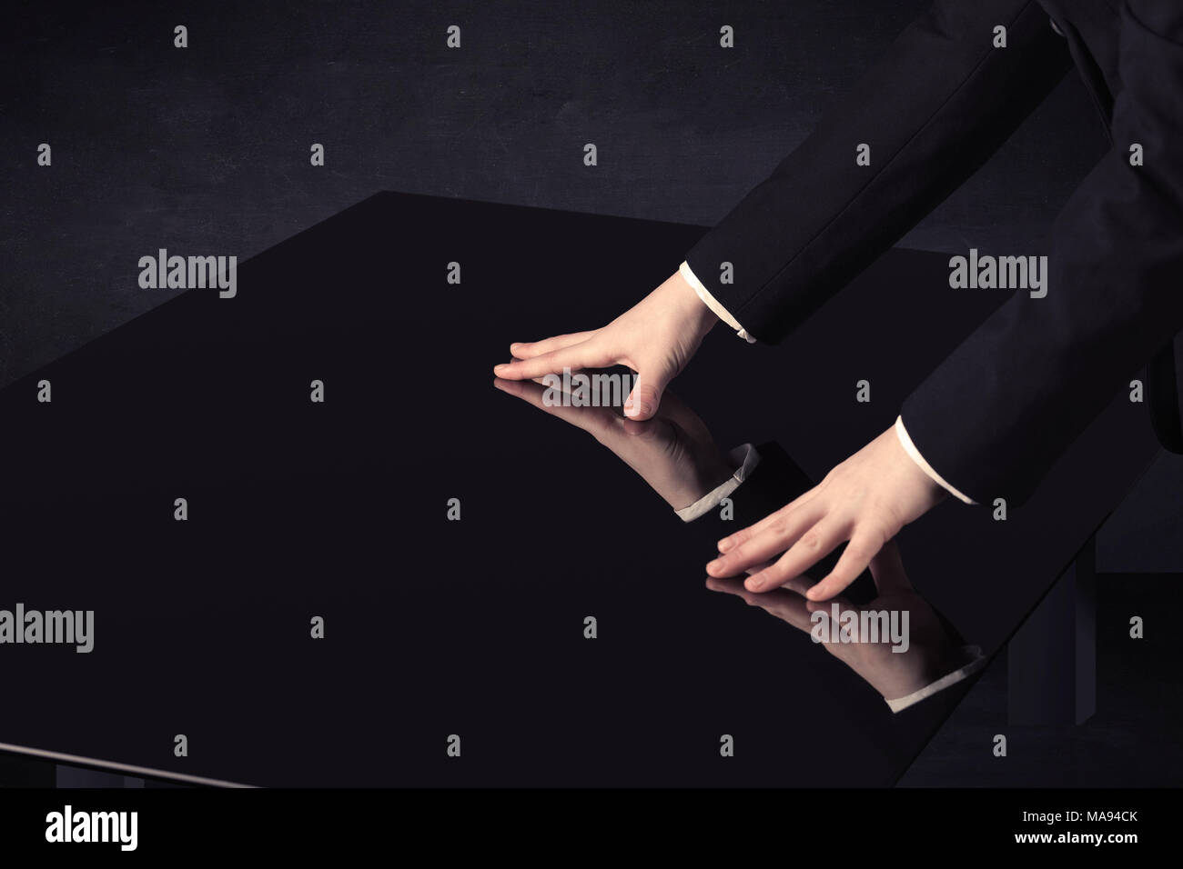 Close up of a hand touching smart table with copy space on black ...
