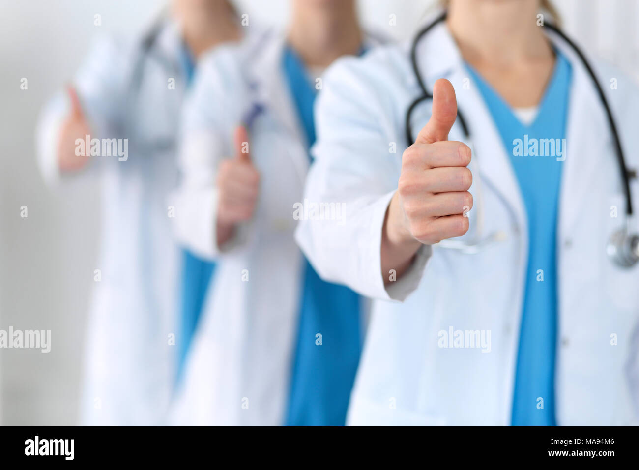 Groupe of medicine doctors show OK sign with thumb up close up. Success ...
