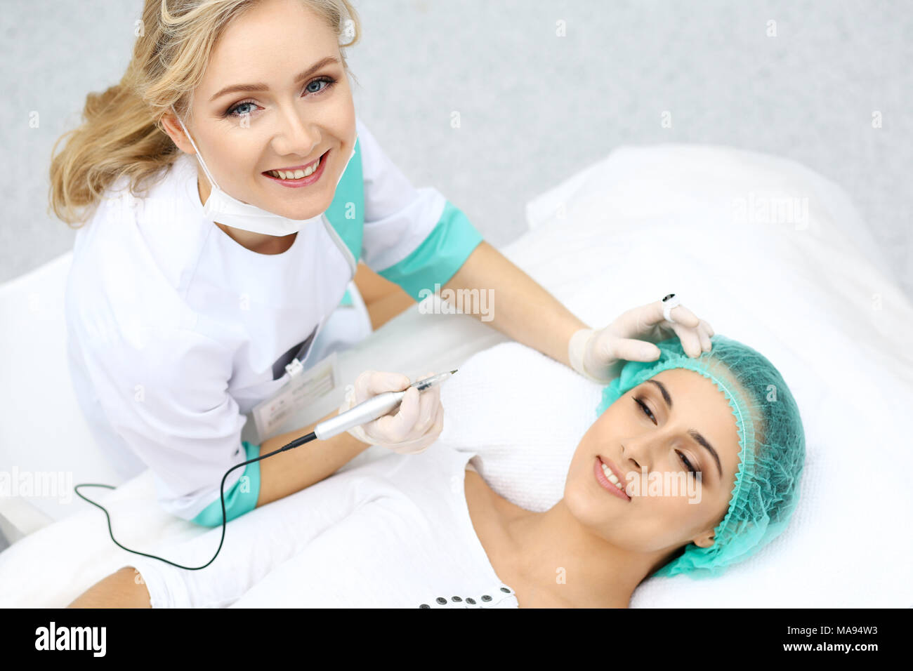 Professional beautician doing eyebrow tattoo at woman face. Permanent ...