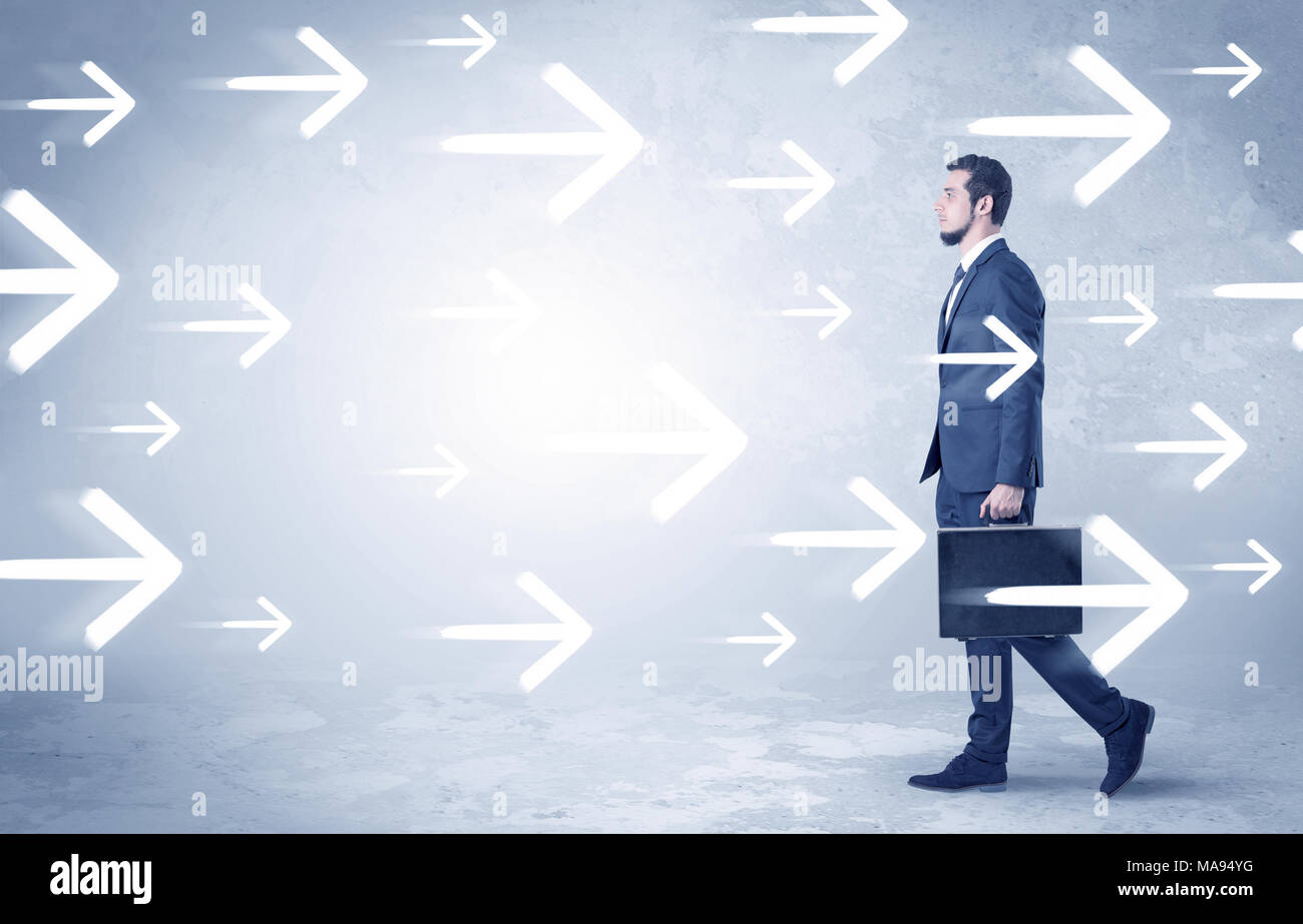 Businessman walking with arrows on the background and briefcase on his ...