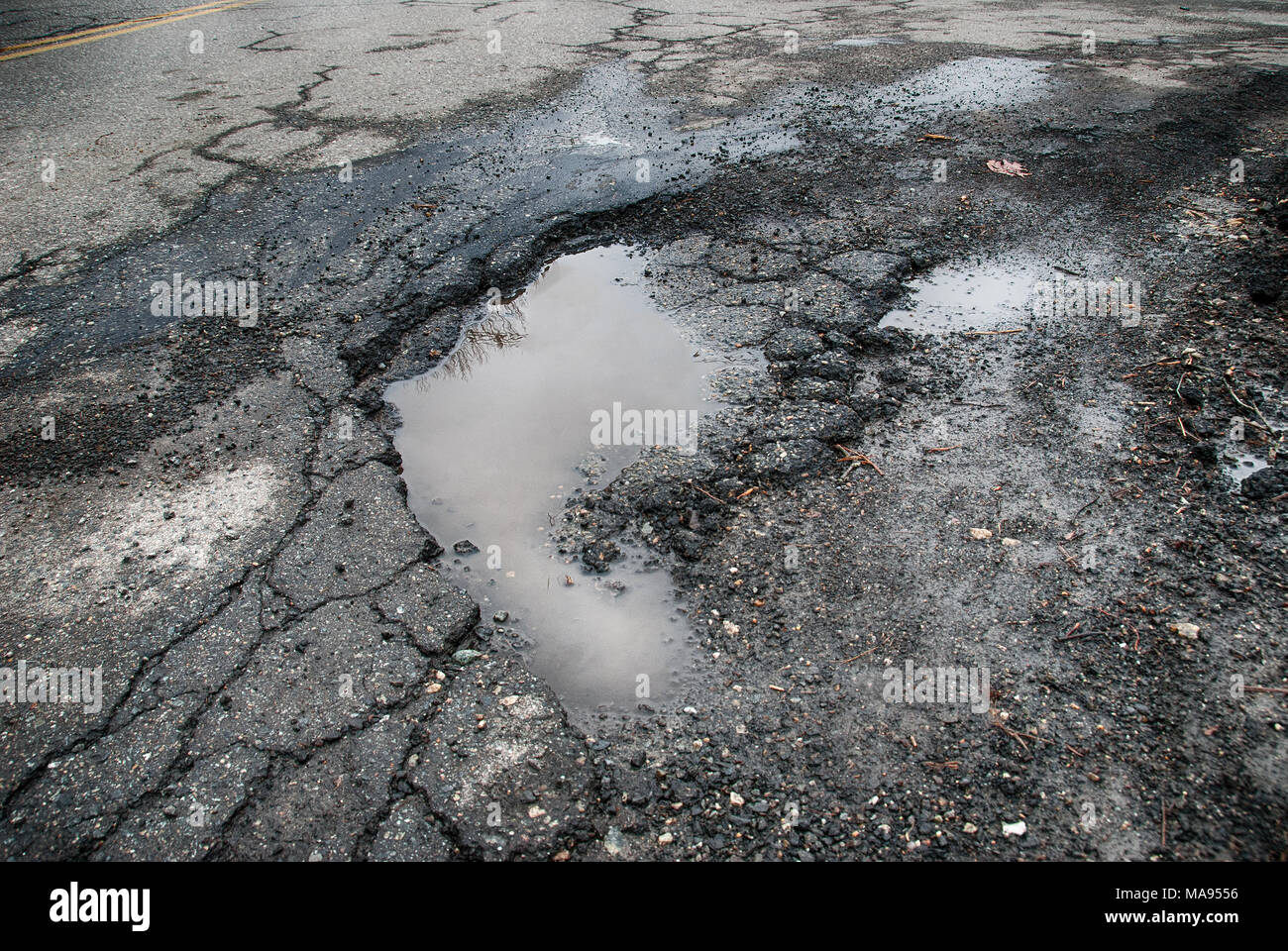 Pothole in road with broken asphalt after spring thaw Stock Photo - Alamy