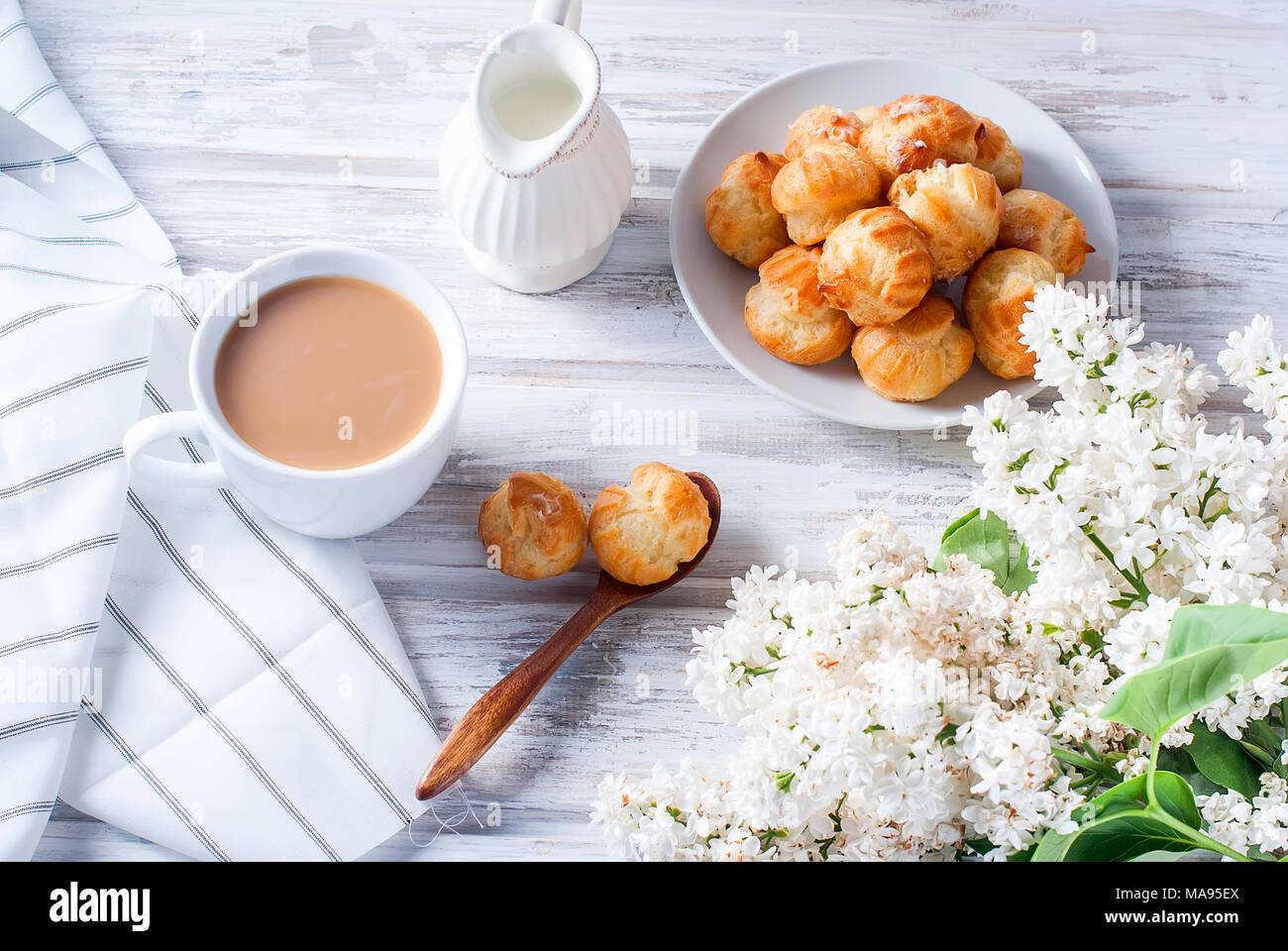 Breakfast, a cup of coffee and eclairs, flowers on a white background ...