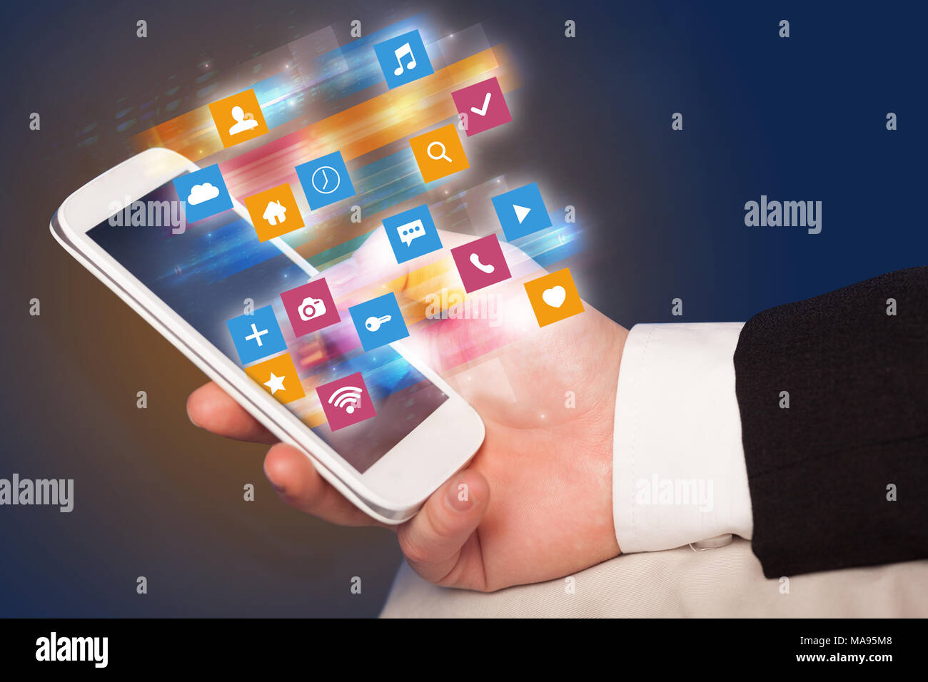 Hand using phone with colorful fast moving application icons and ...