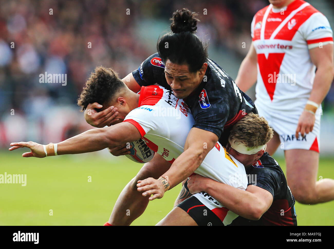 Wigan Warriors' Taulima Tautai tackles St Helens' Regan Grace during ...