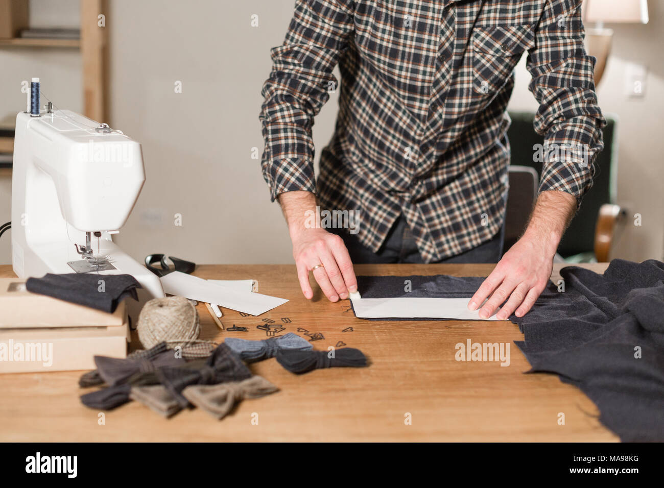 Cutting dark wool fabric. the line pattern. Young man working as a ...