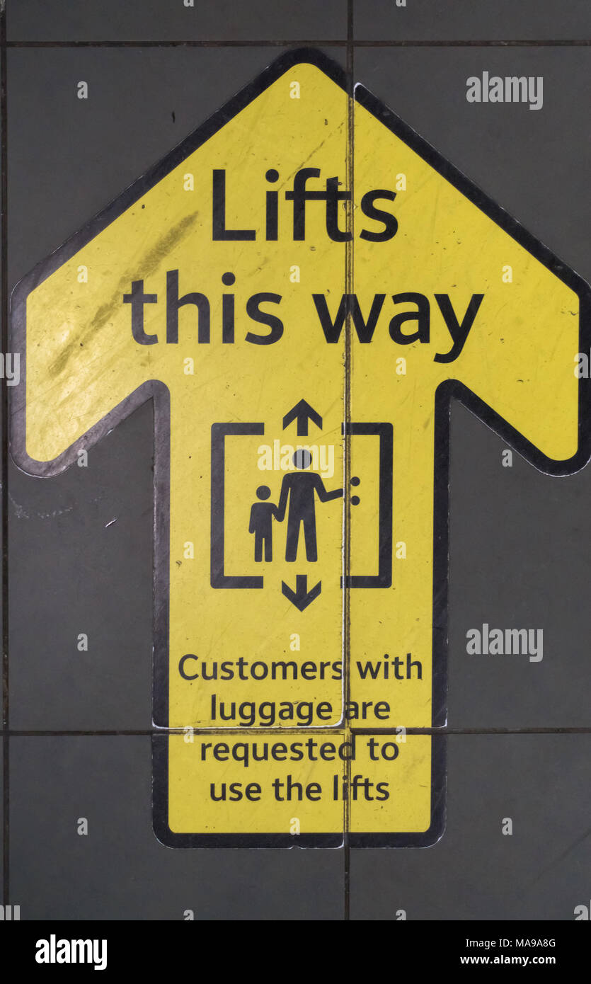 A yellow arrow on the floor gives diractions to the lifts Stock Photo ...