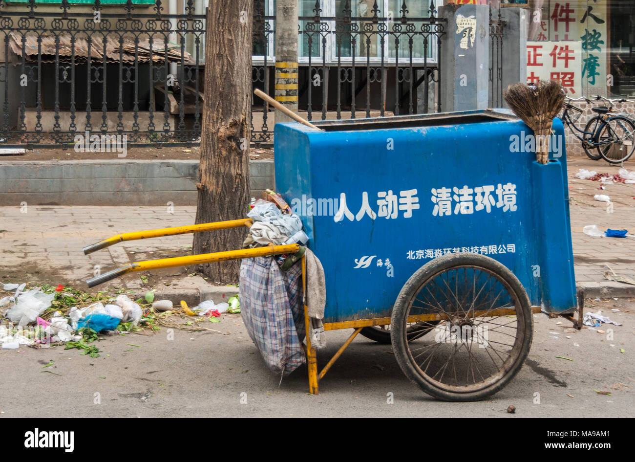 Beijing, China - April 26, 2010: Closeup of yellow trash collection ...