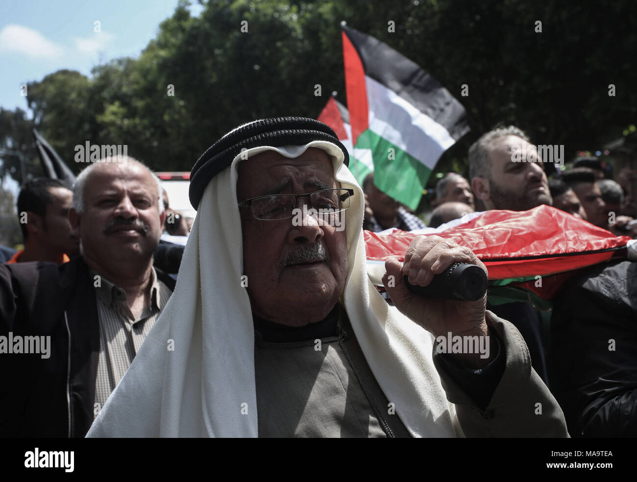 Palestinians take part in a symbolic funeral in solidarity with those ...