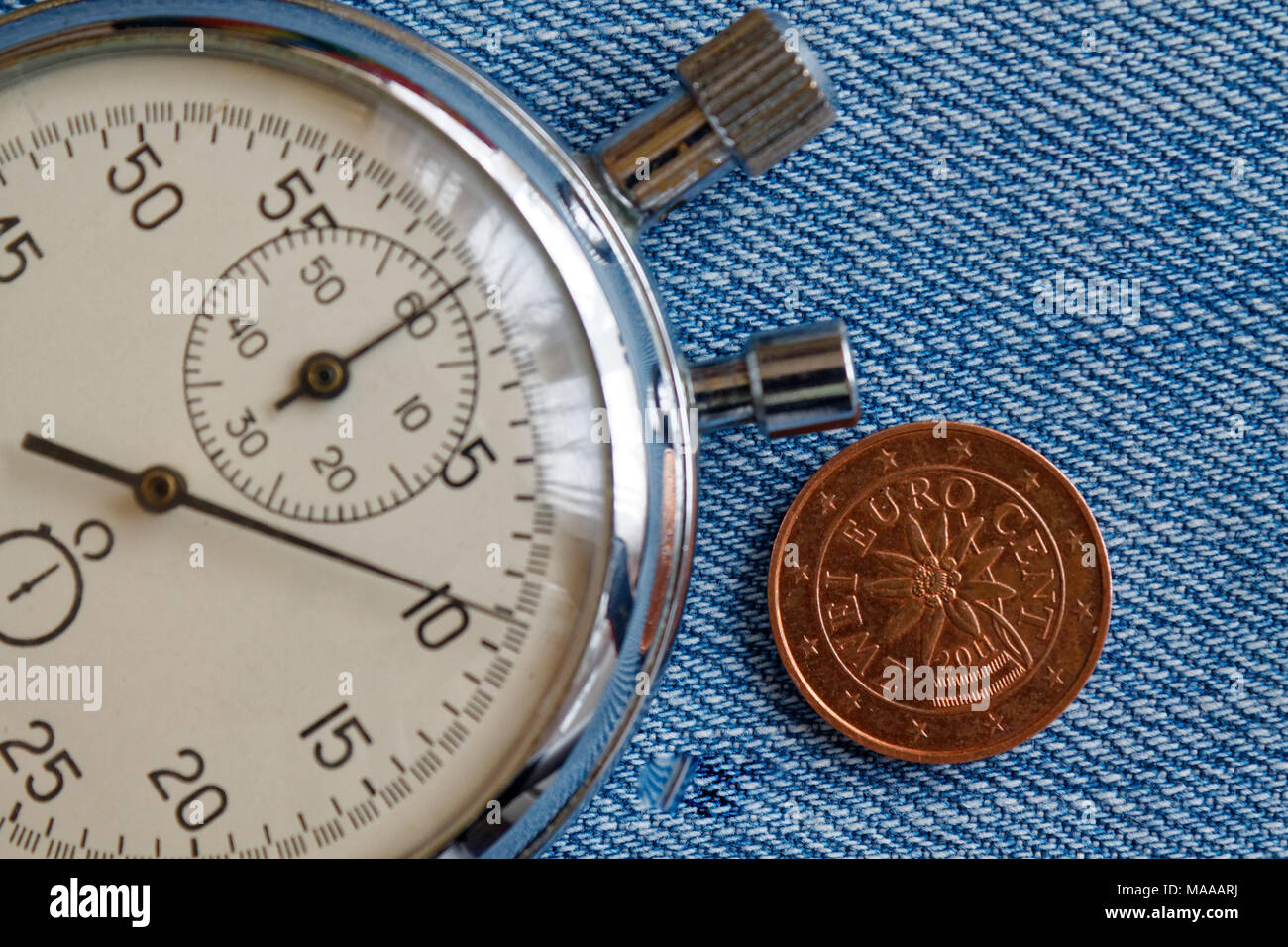 Euro coin with a denomination of 2 euro cents (back side) and stopwatch ...
