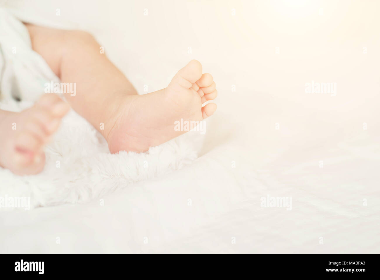 Newborn Baby legs on white bed Stock Photo - Alamy