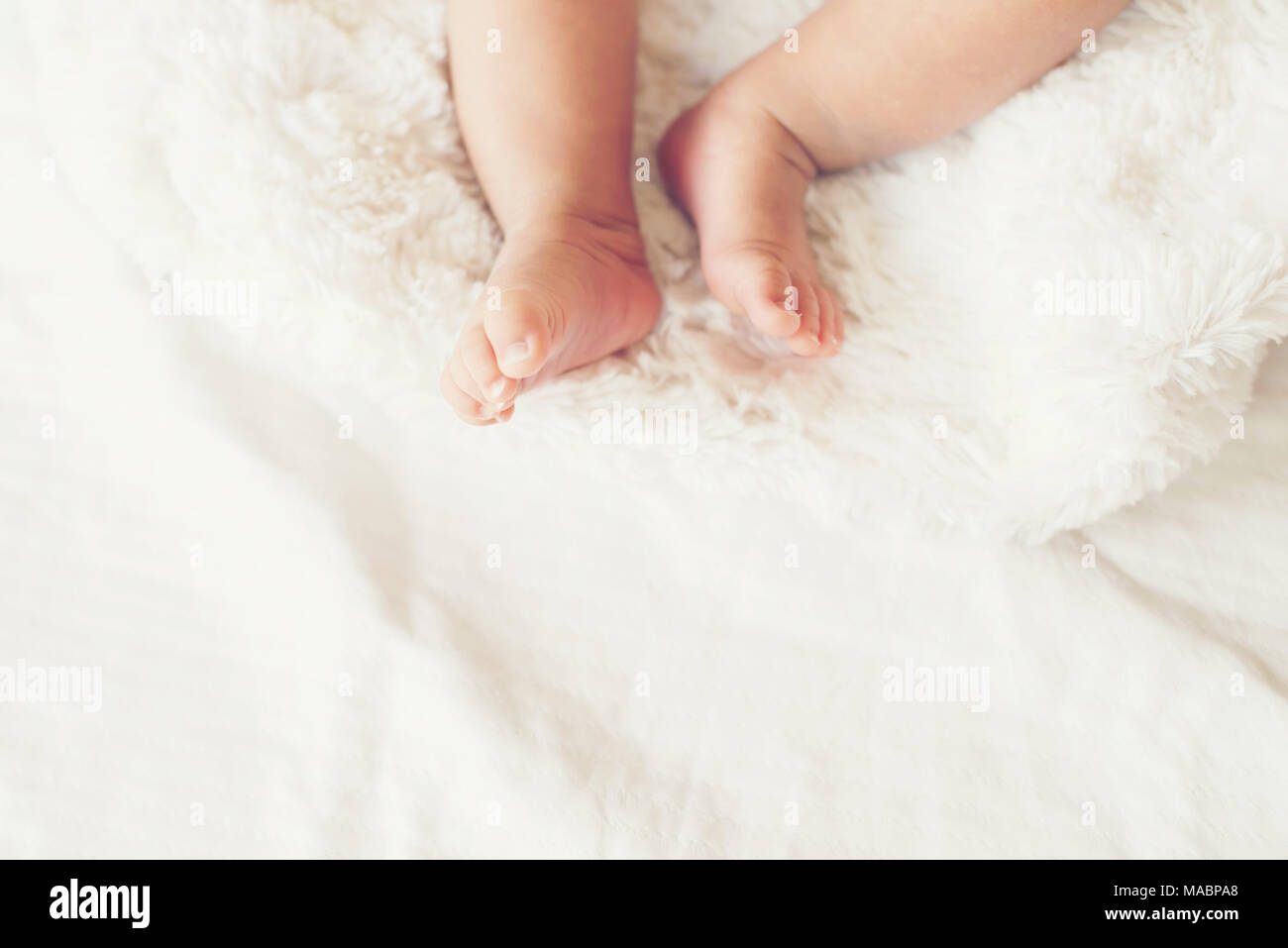 Newborn Baby legs on white bed Stock Photo - Alamy