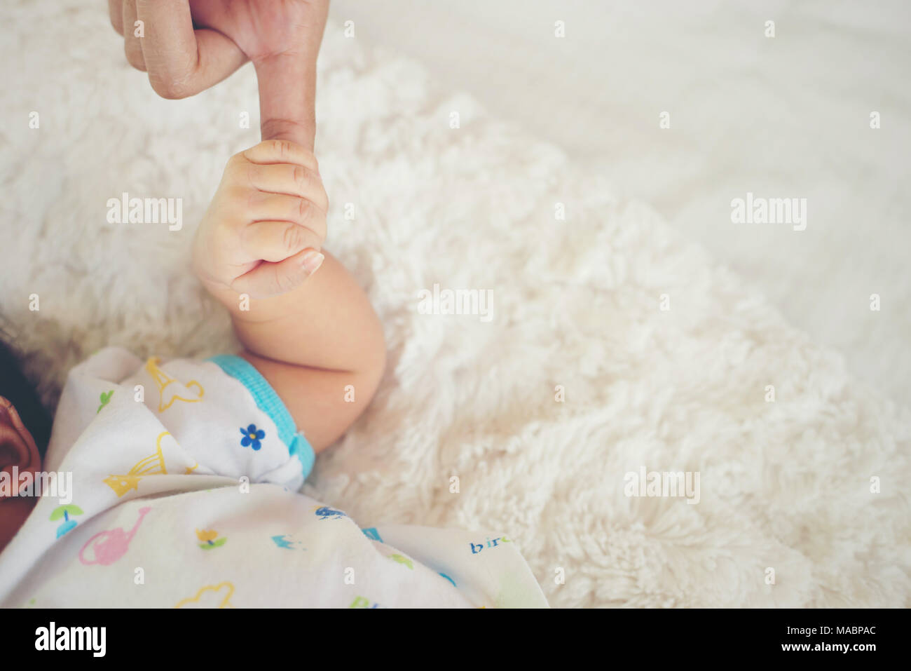 Newborn baby hand on white bed Stock Photo - Alamy