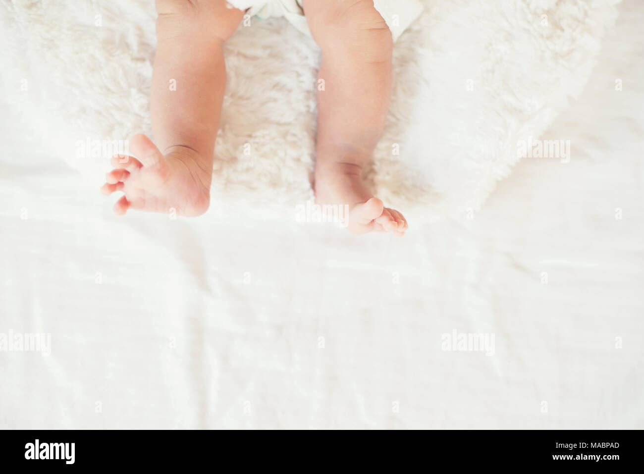 Newborn Baby legs on white bed Stock Photo - Alamy