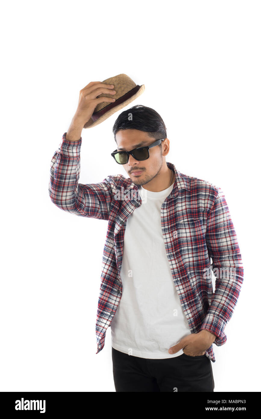 Portrait of young hipster man adjusting hat with head at camera on ...