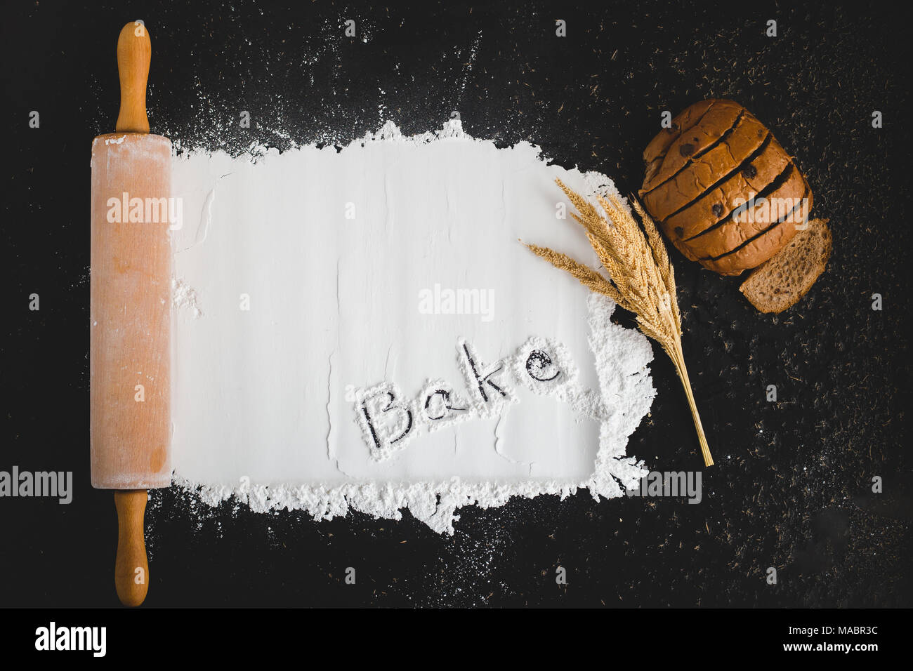 Rolling pin with flat flour and bread on black chalkboard with word ...