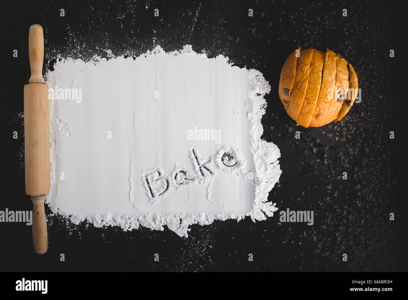 Rolling pin with flat flour and bread on black chalkboard with word ...