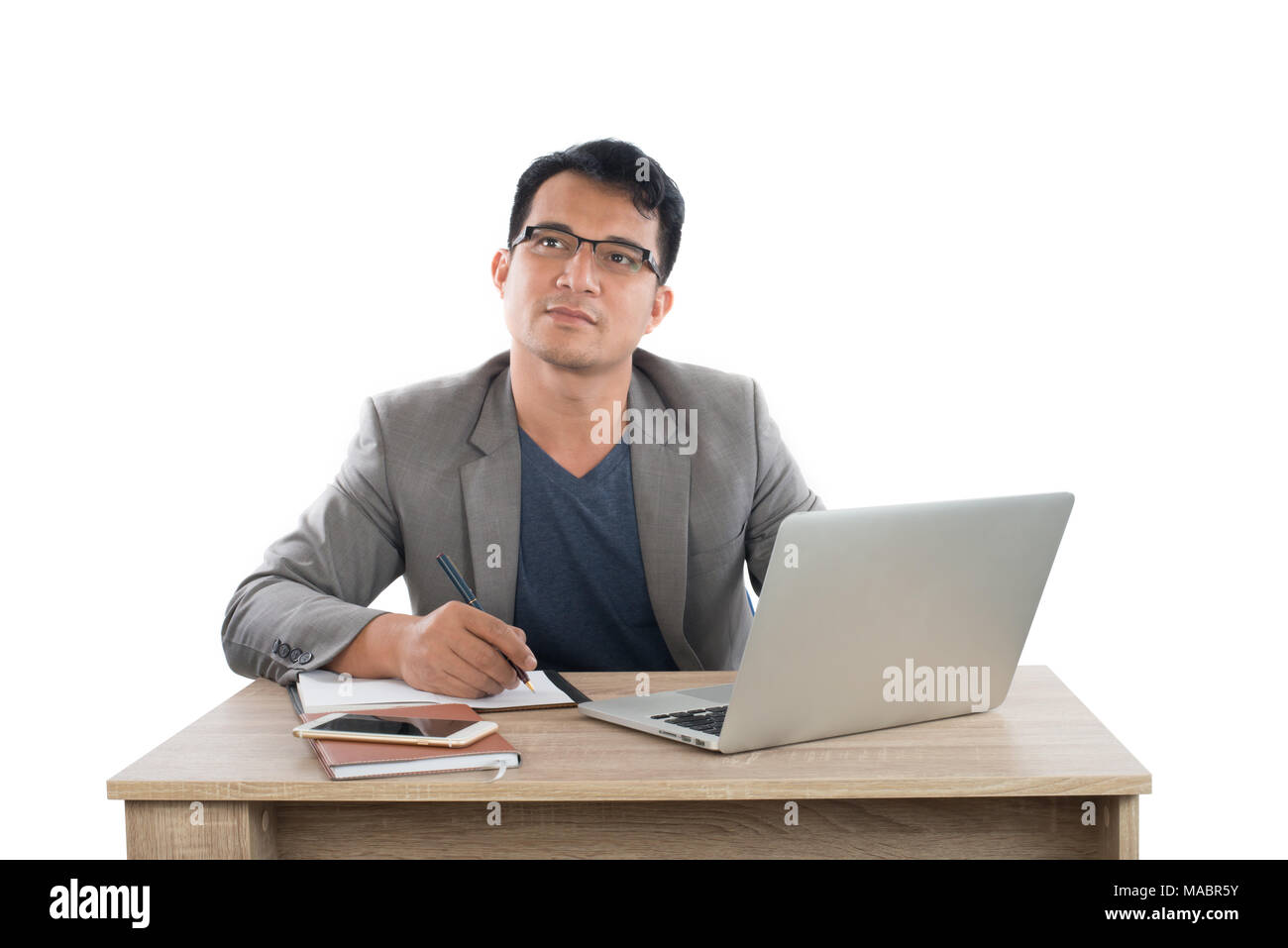 businessman writing notes on a writing pad while sitting at his desk ...