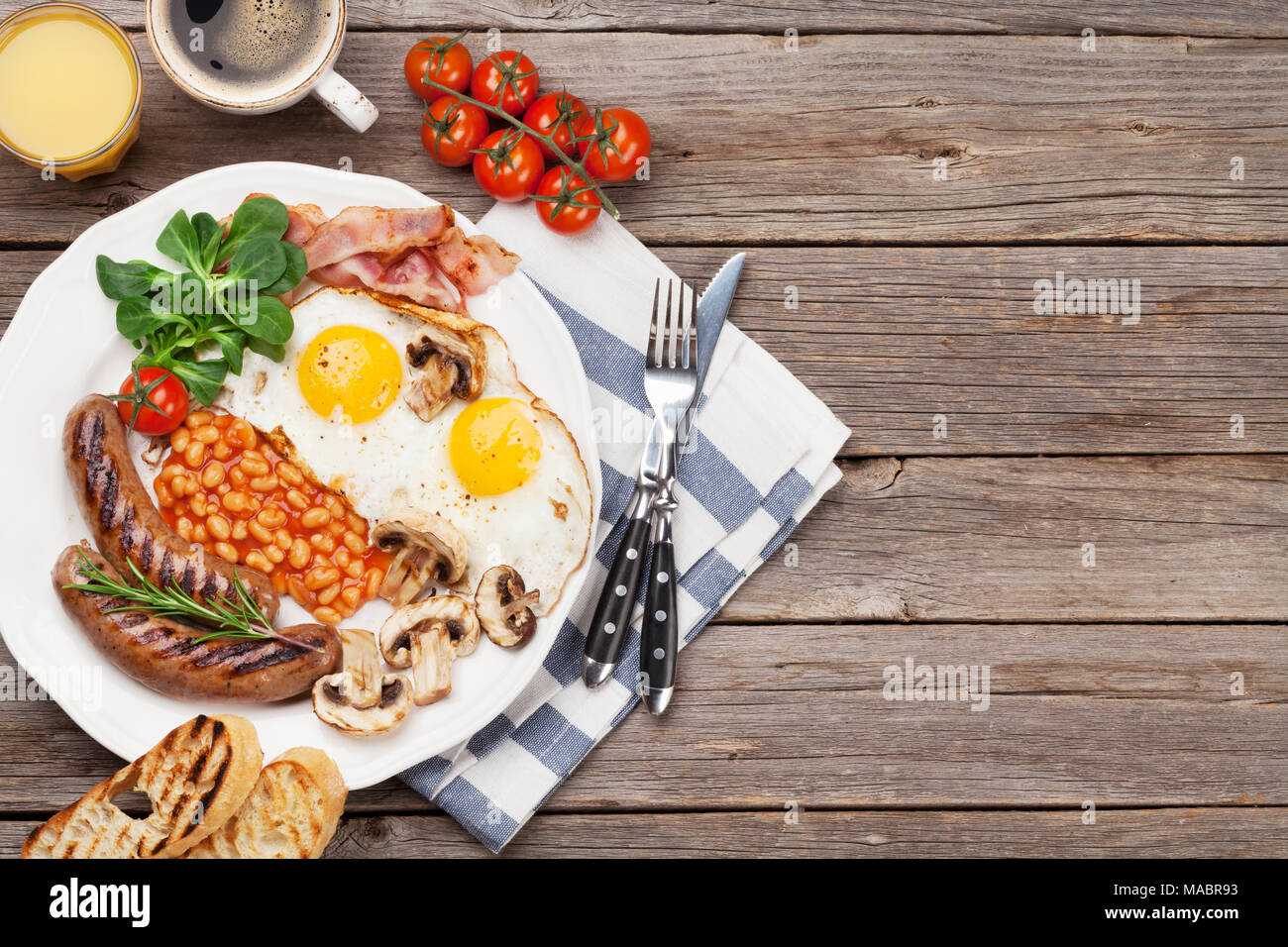 English breakfast. Fried eggs, sausages, bacon, beans, toasts, tomatoes ...