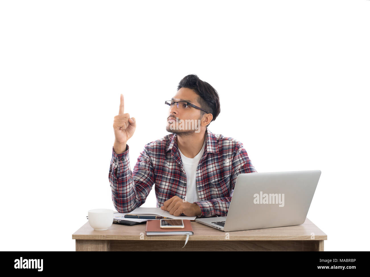 Young businessman pointing finger up at workplace thoughtful with work ...