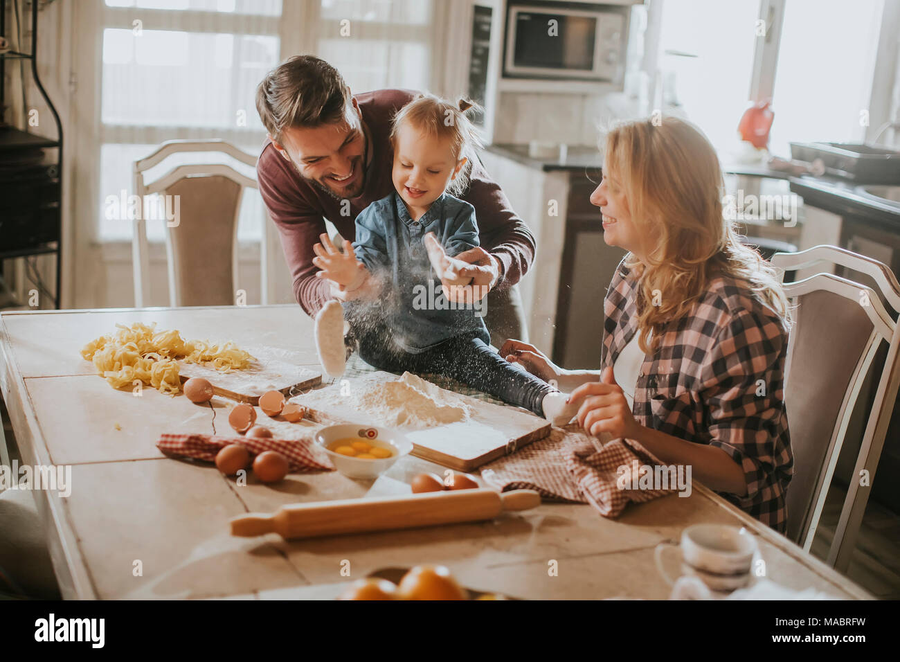Happy family making pasta in the kitchen at home Stock Photo - Alamy