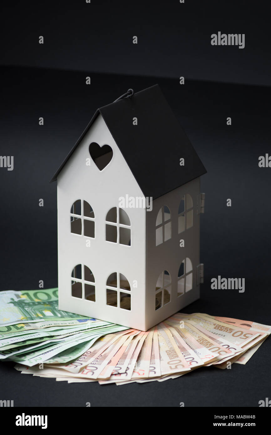 Money on a small house . fifty and hundred banknotes.mortgage concept ...