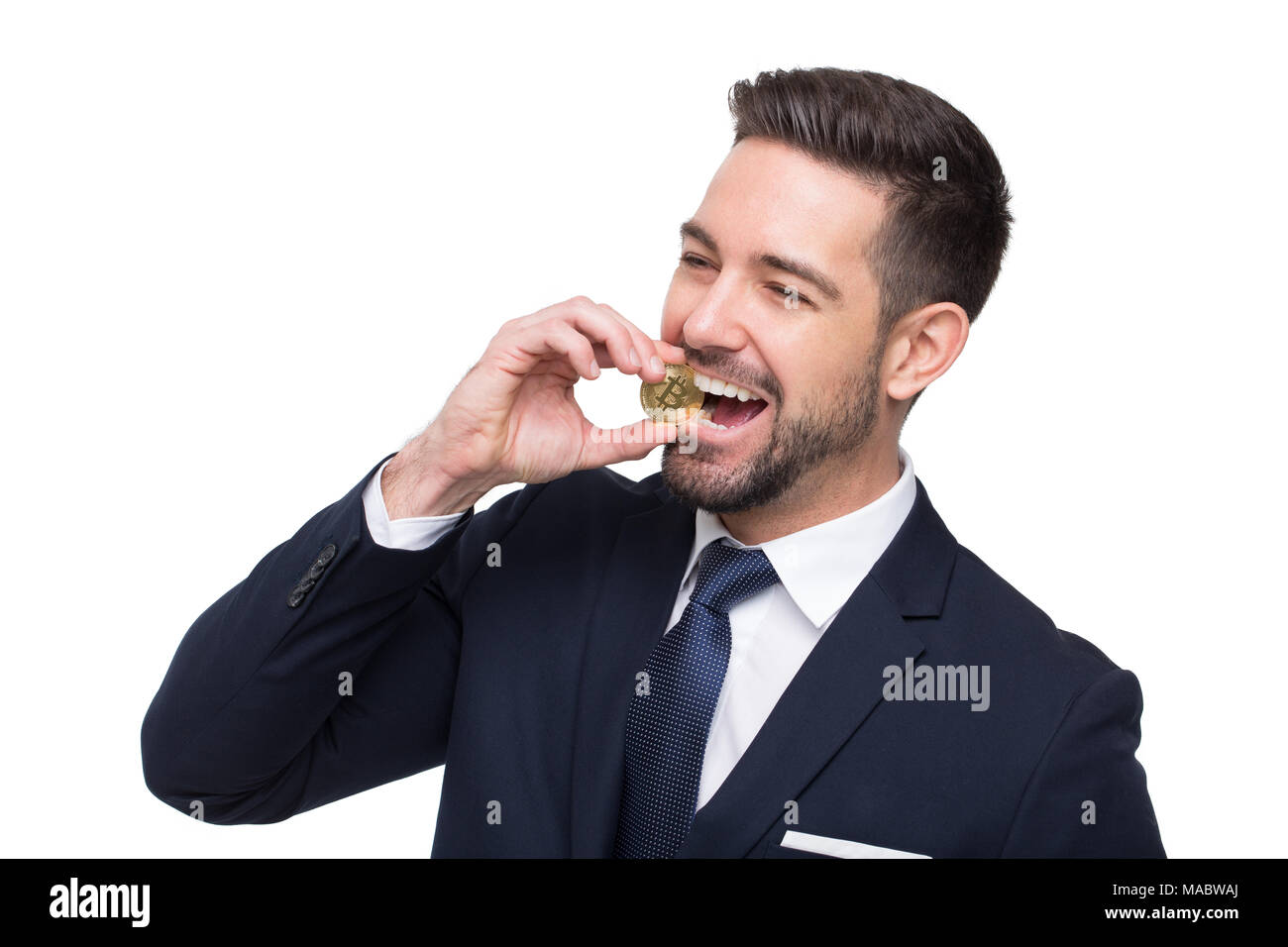Young caucasian businessman bite into golden bitcoin coin, isolated on ...