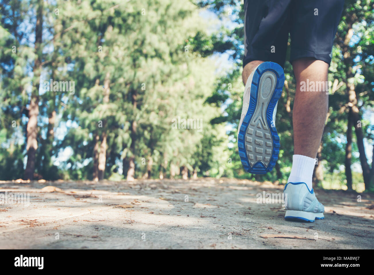 close up foot of young runner man running along road in the park Stock ...