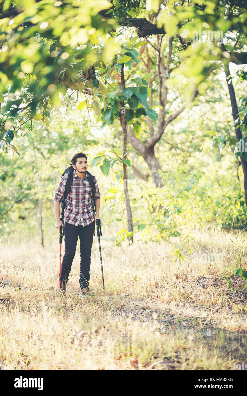 Young hipster man walking on the rural road during hikes on vacation ...
