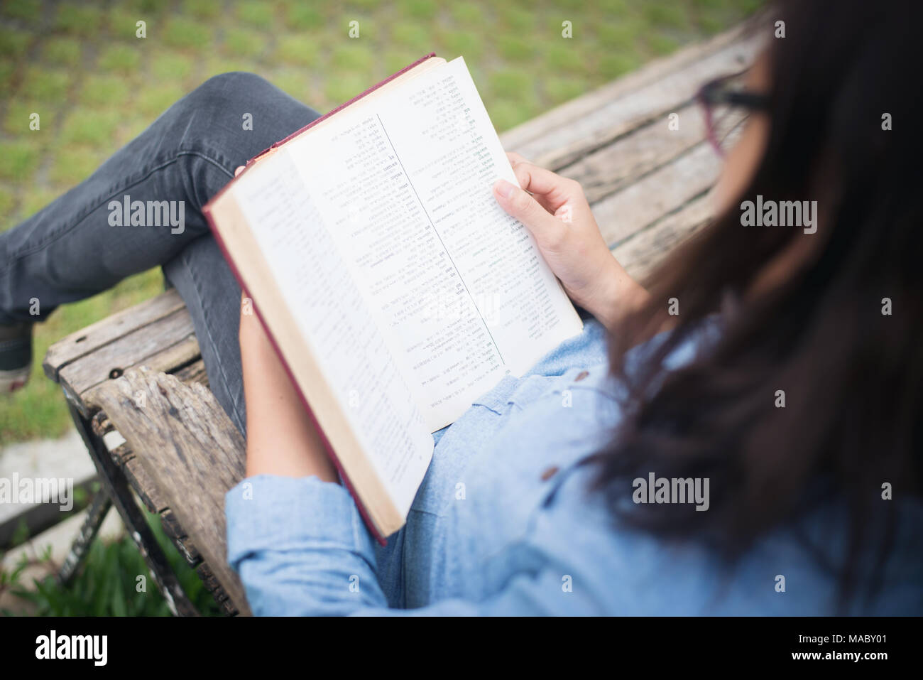 Hipster charming girl relaxing in the park while read book, Enjoy ...