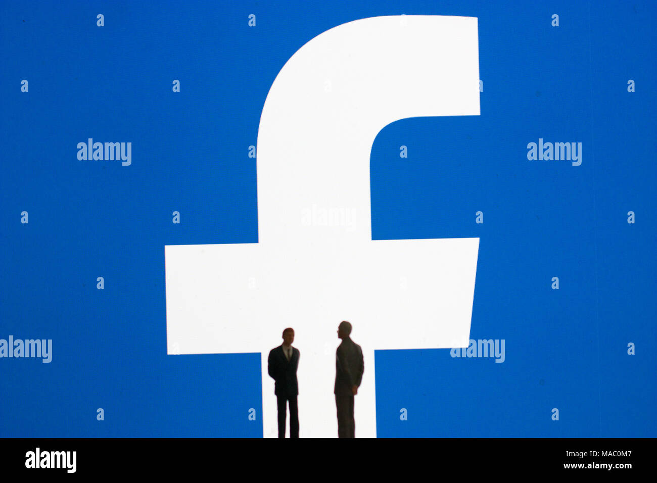 Facebook logo with models of people in foreground Stock Photo - Alamy