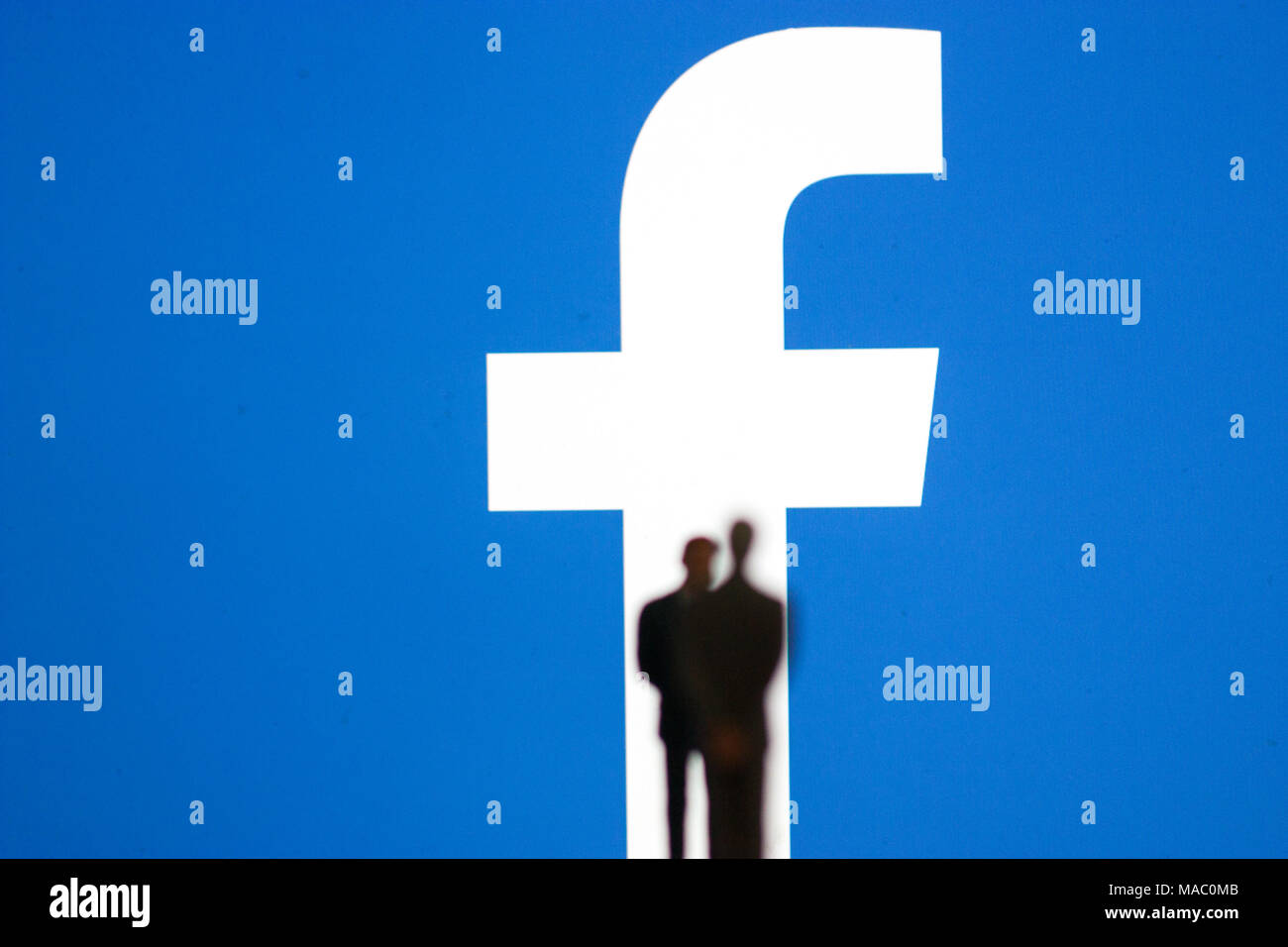 Facebook logo with models of people in foreground Stock Photo - Alamy
