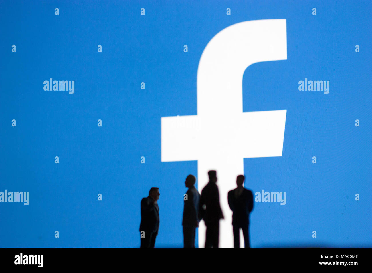 Facebook logo with models of people in foreground Stock Photo - Alamy