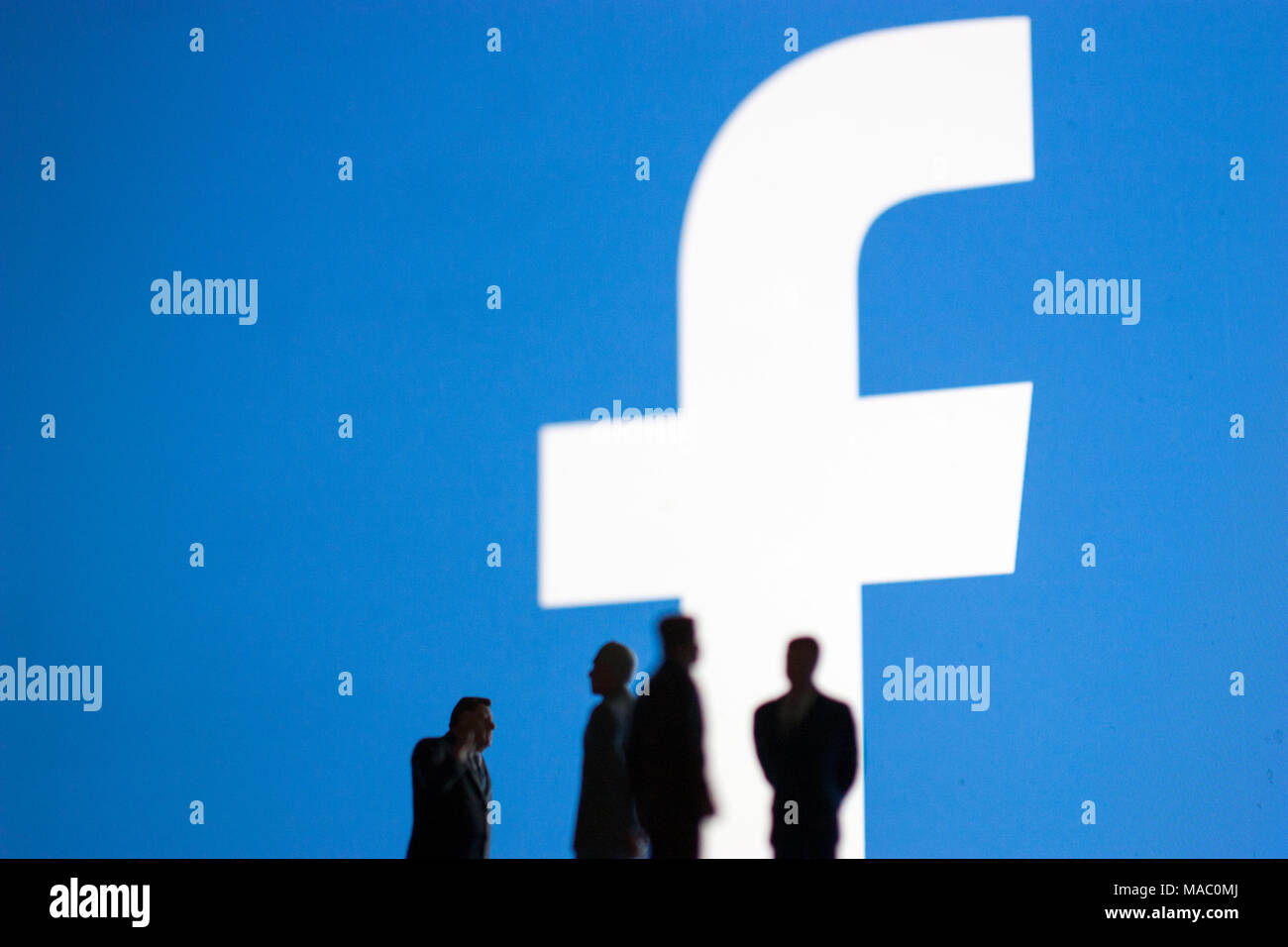 Facebook logo with models of people in foreground Stock Photo - Alamy