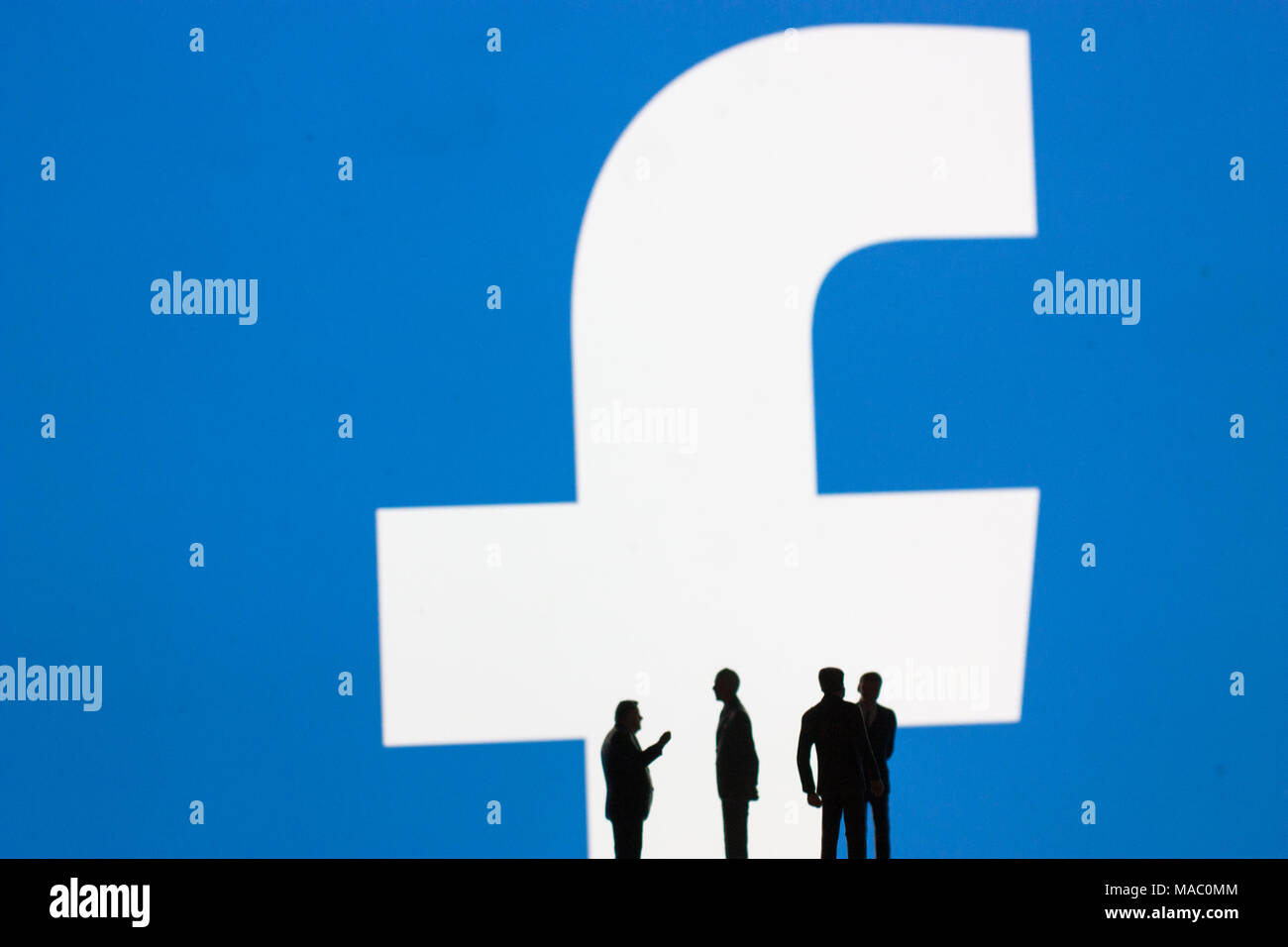 Facebook logo with models of people in foreground Stock Photo - Alamy