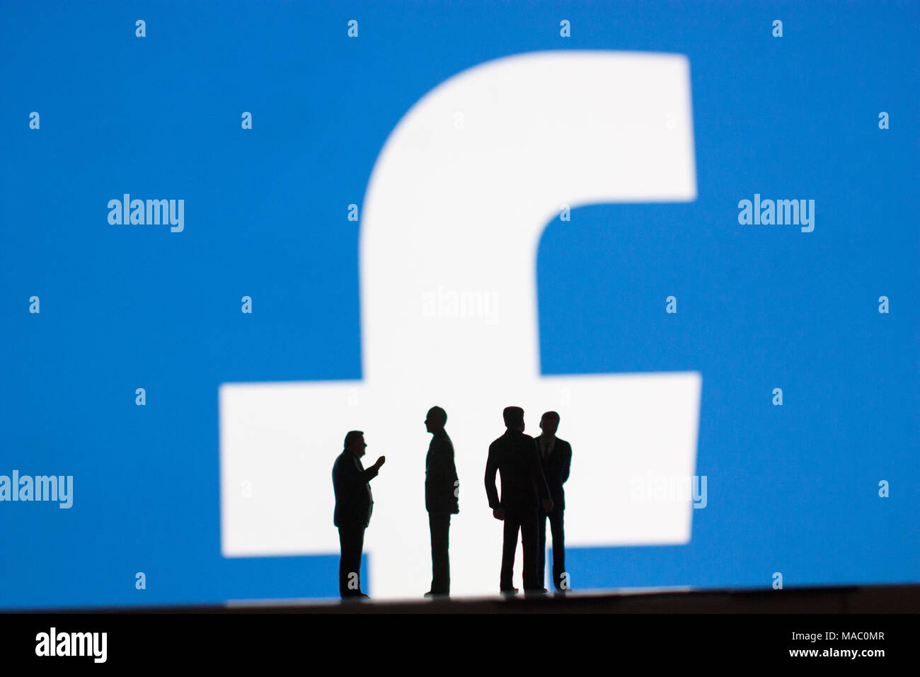 Facebook logo with models of people in foreground Stock Photo - Alamy