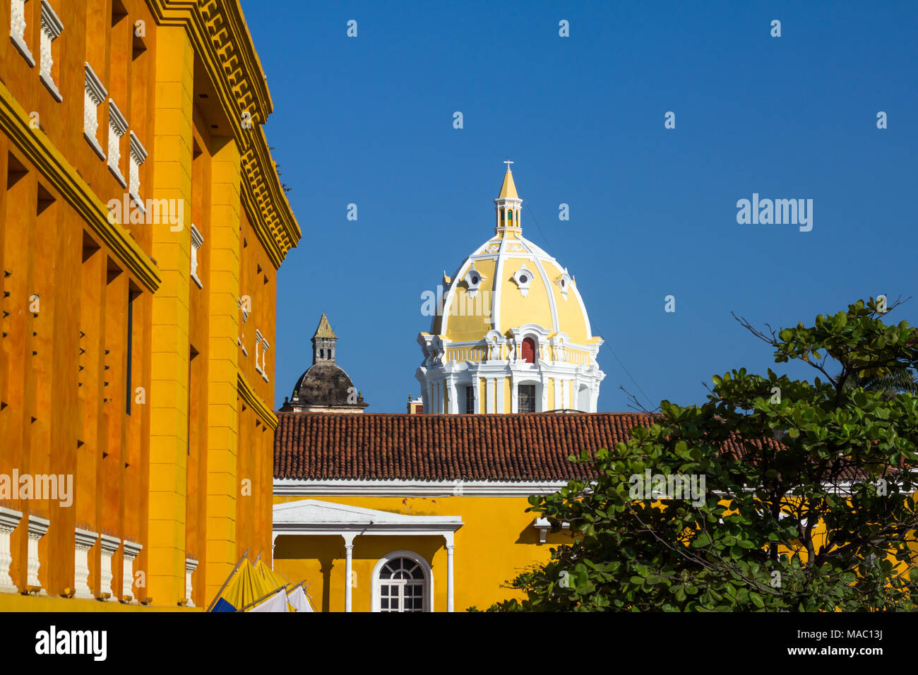 Peaking above terracotta tile roof is the ornate, pale lemon colored ...