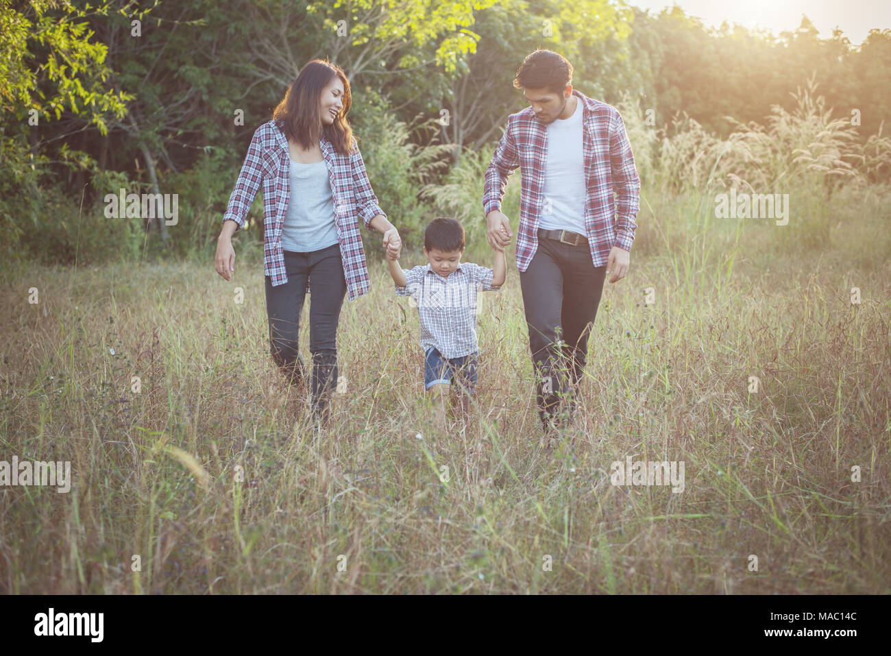 Happy young family spending time together outside in green nature park ...