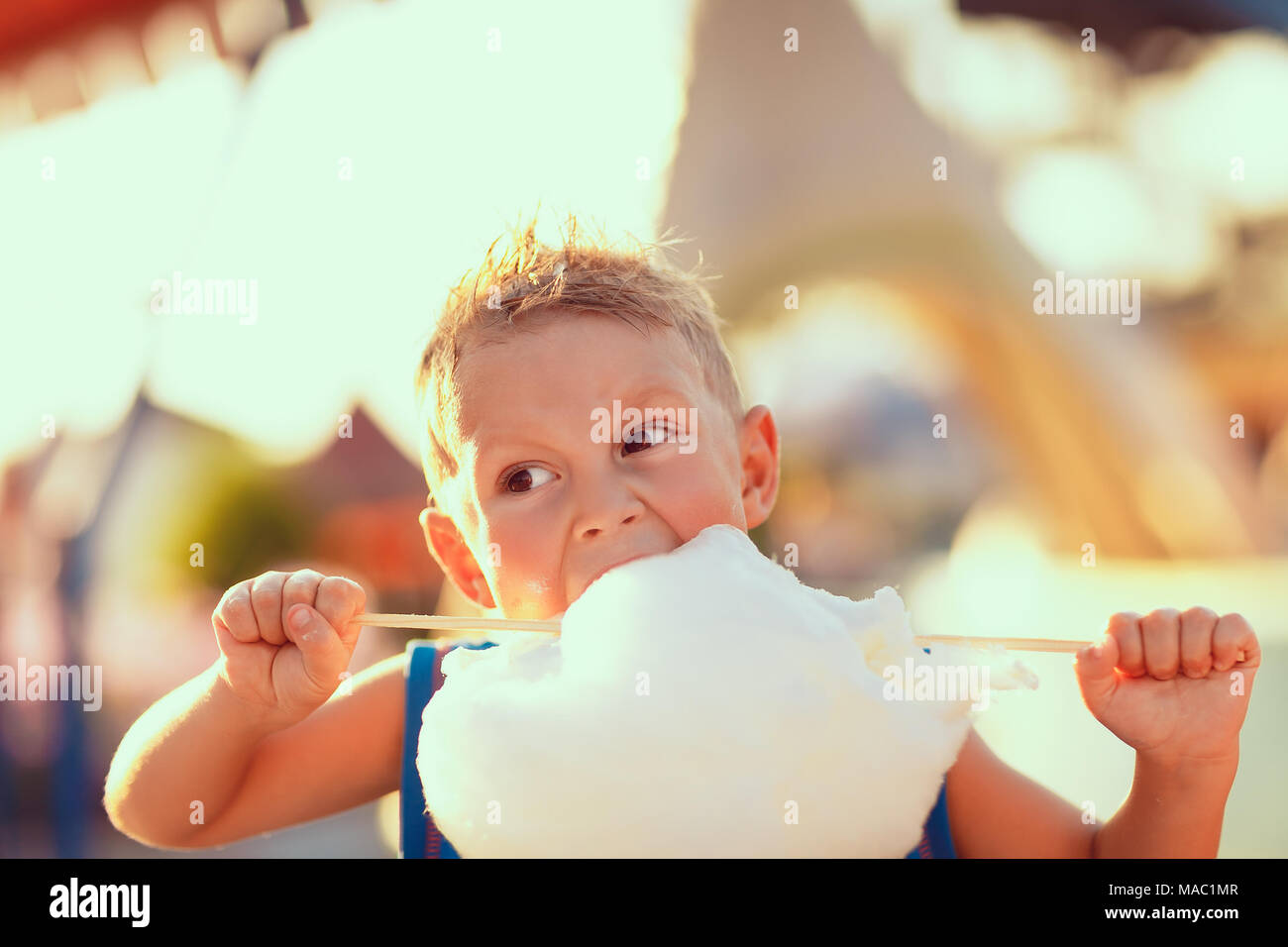 Young boy eating candy floss Stock Photo - Alamy