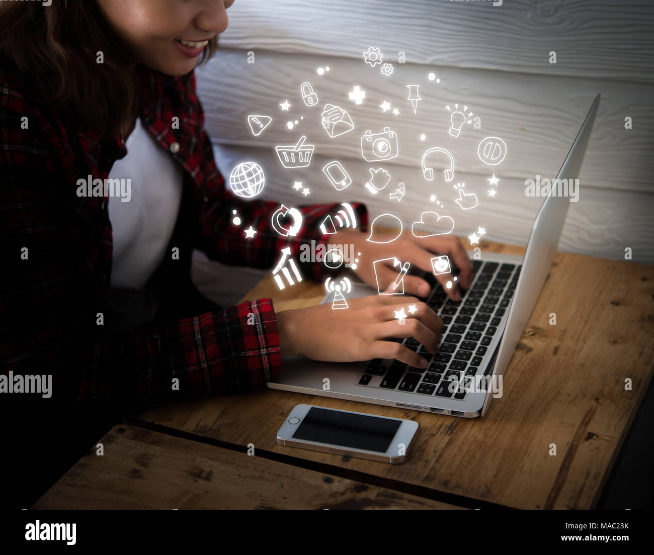 Woman typing on her laptop with doodle multimedia doodle icon ejected ...