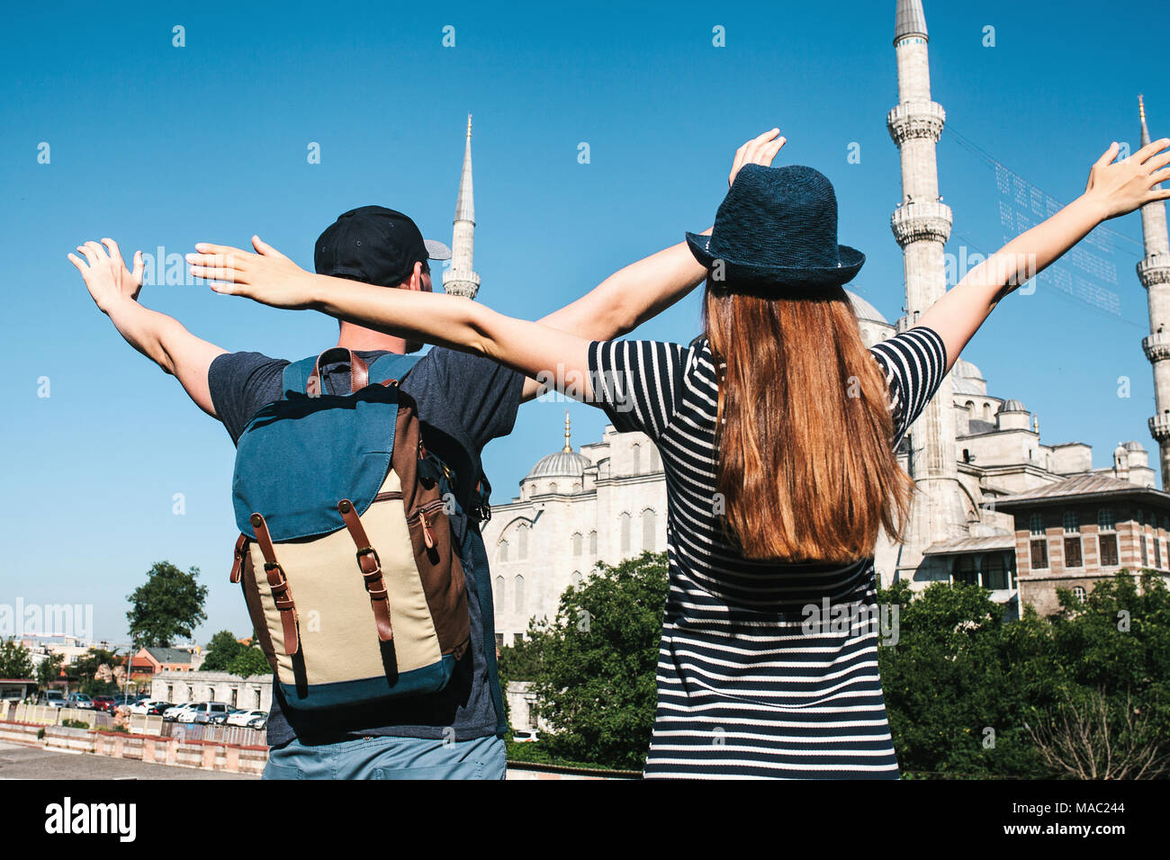 A couple of tourists a young man and a pretty woman next to the world ...