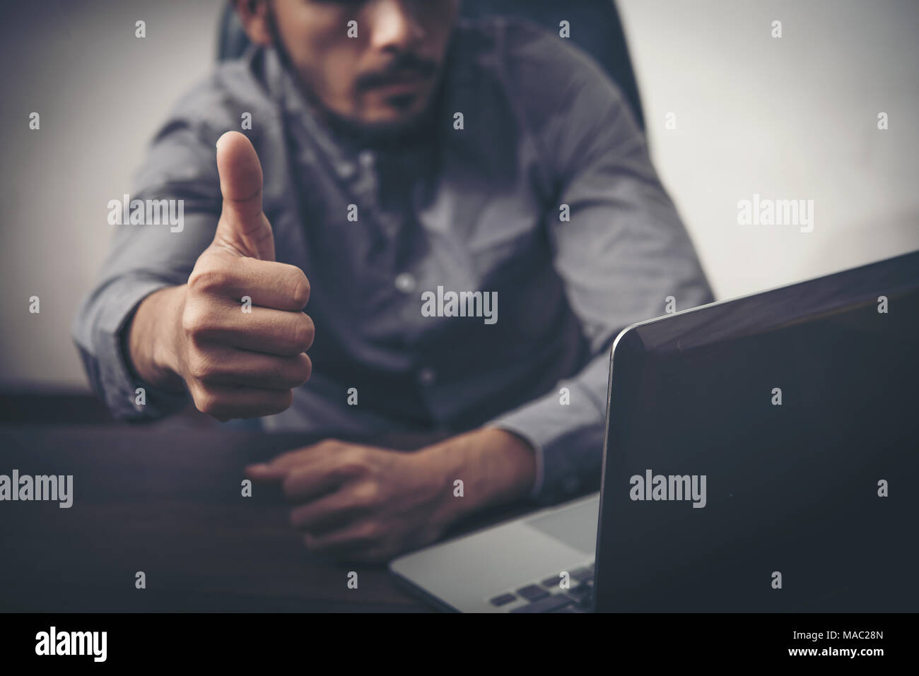 Businessman thumbs up while working with his laptop computer. Business ...