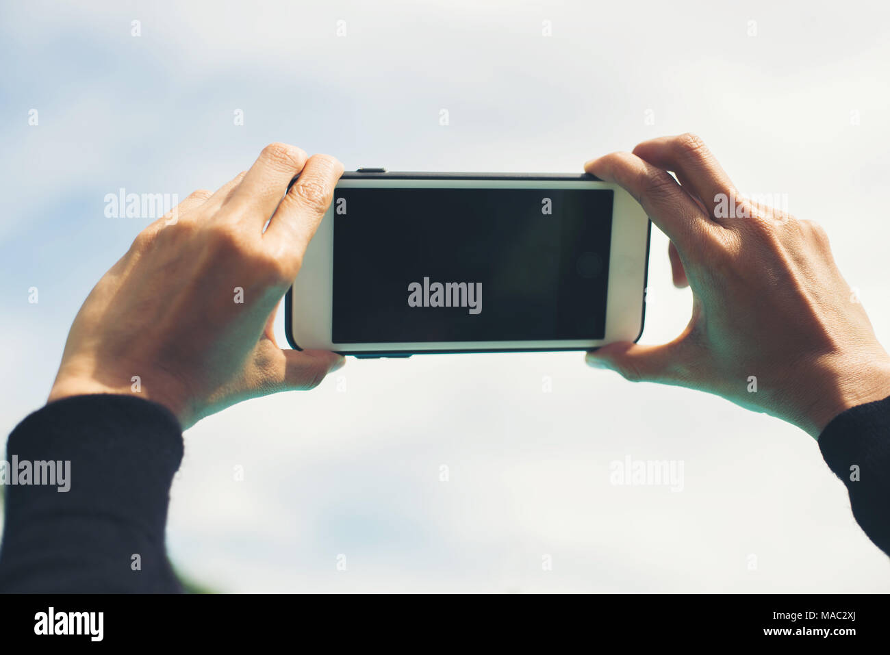 Female hands taking photo with smartphone, view of blue sky and cloud ...